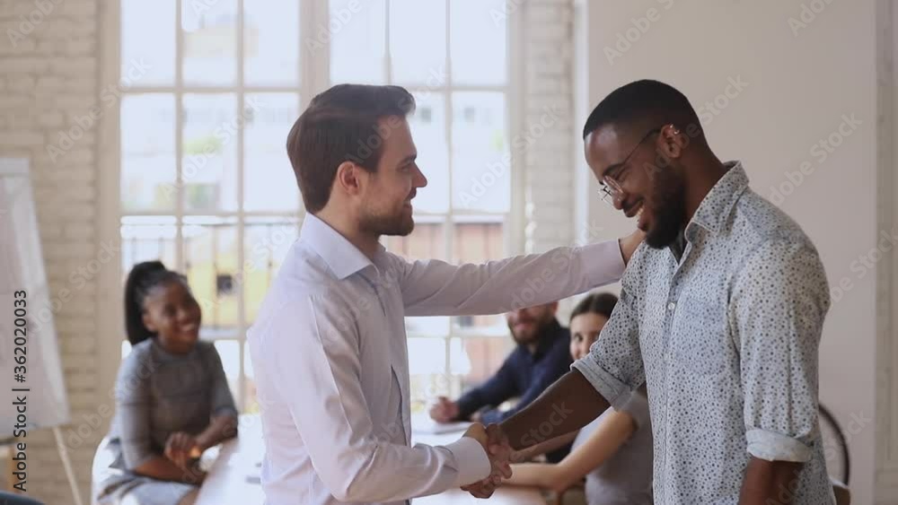 Proud caucasian manager boss handshaking congratulating praising male ...
