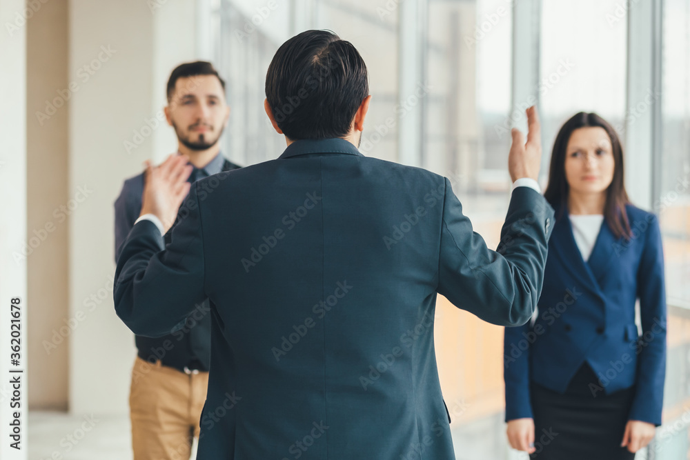 Angry boss standing back to the camera, shouting at his workers ...
