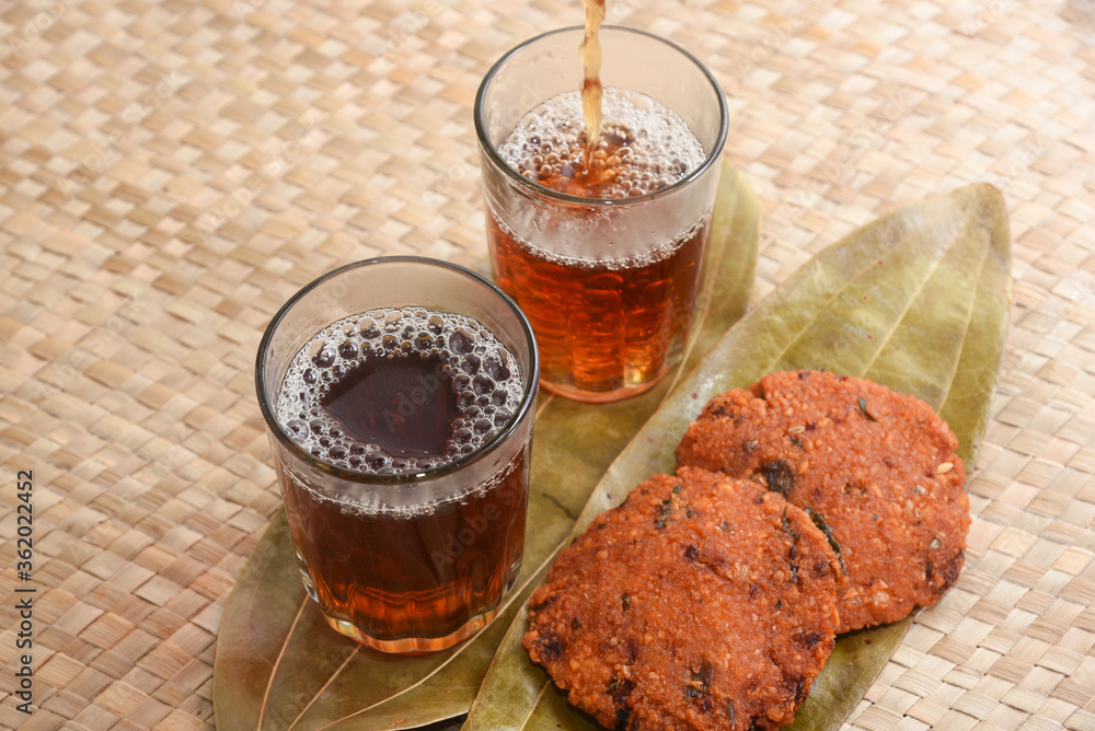 Cup of black tea and heap of dried organic tea leaves, dust and infuser ...