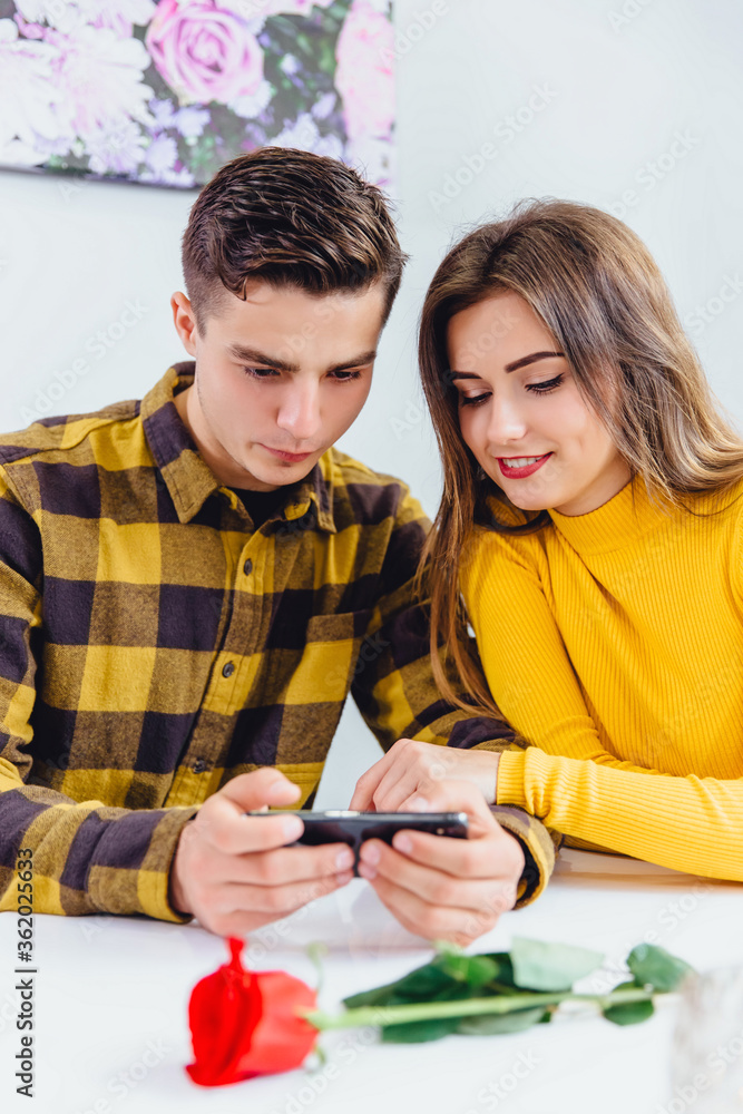 Funny couple playing games on smart phone, while they are waiting for ...