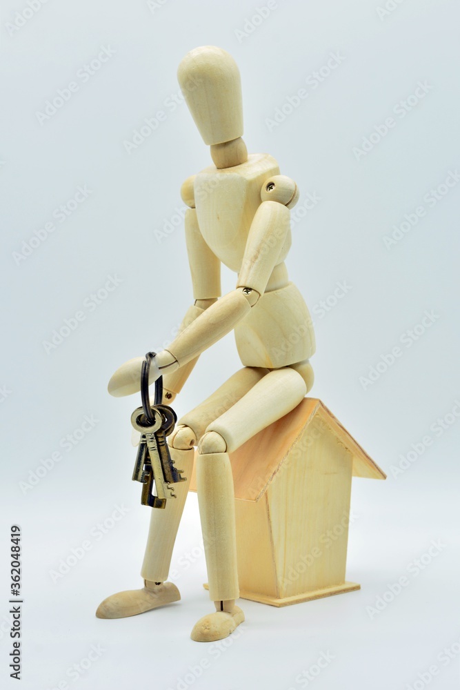 Maniquí de madera sentado en una casa con un manojo de llaves en la ...