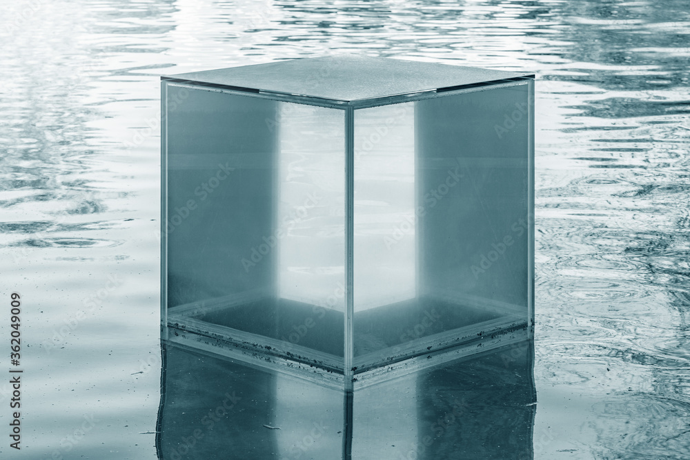 Cube made from glass on the water surface. Stock Photo | Adobe Stock