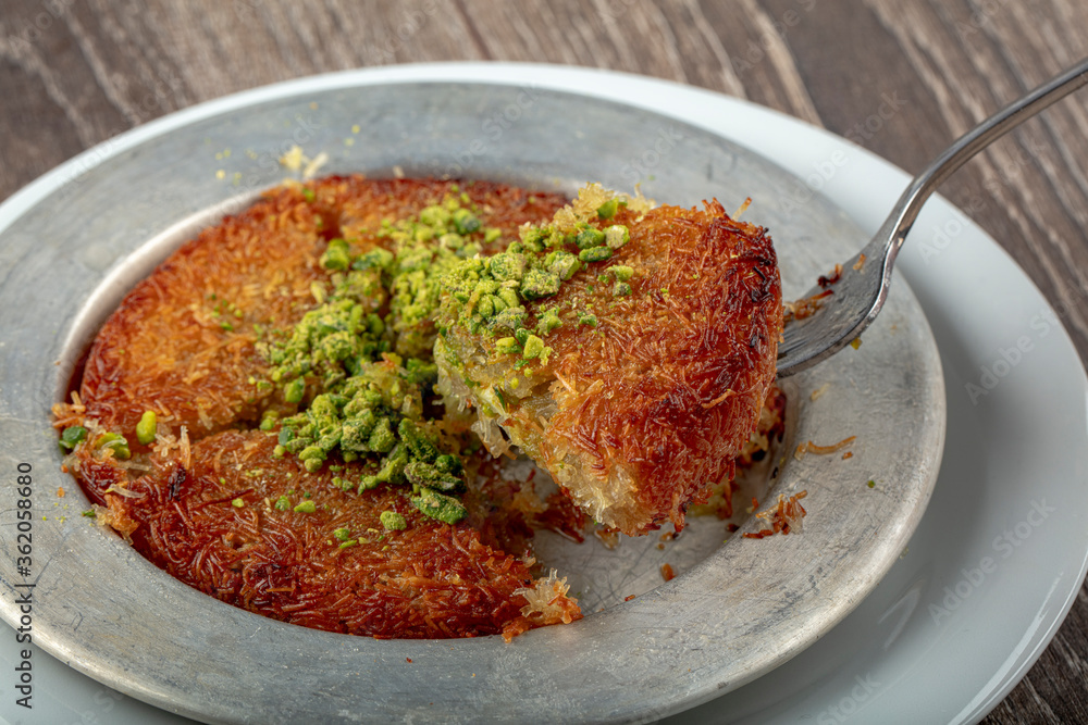 Turkish dessert kunefe, kunafa, kadayif with pistachio powder and ...