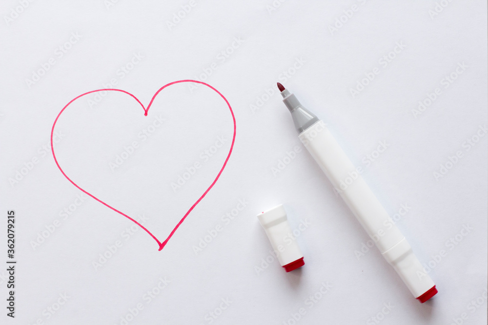 Drawn by a bright red felt-tip pen or marker a red heart on white paper ...