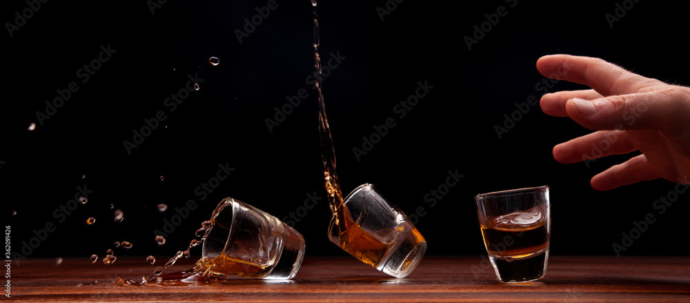 Shot glass of whiskey tipping over Stock Photo | Adobe Stock