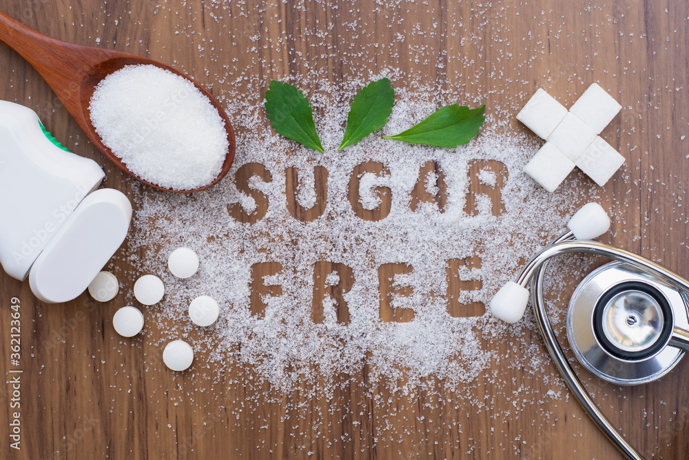 Foto de White sugar in wooden spoon and words " sugar free " letters ...