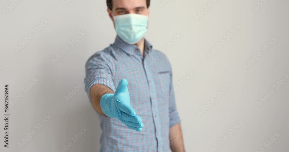 On gray studio background 35s man wears medical face mask and gloves ...