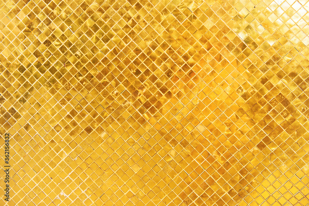 Closeup view of wall surface with many gold shiny mosaic squares. Can ...
