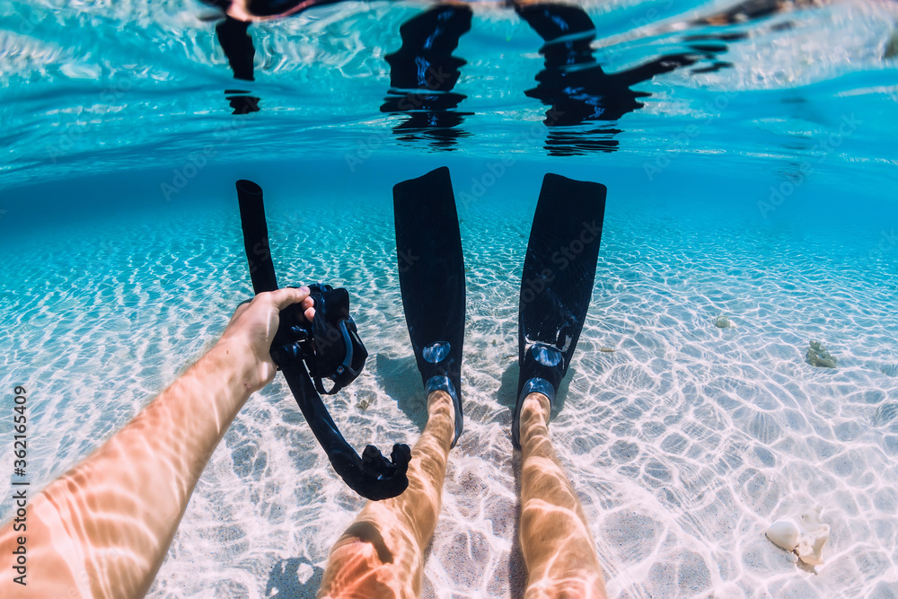 Freediver relax with fins and mask on sand bottom in blue ocean ...
