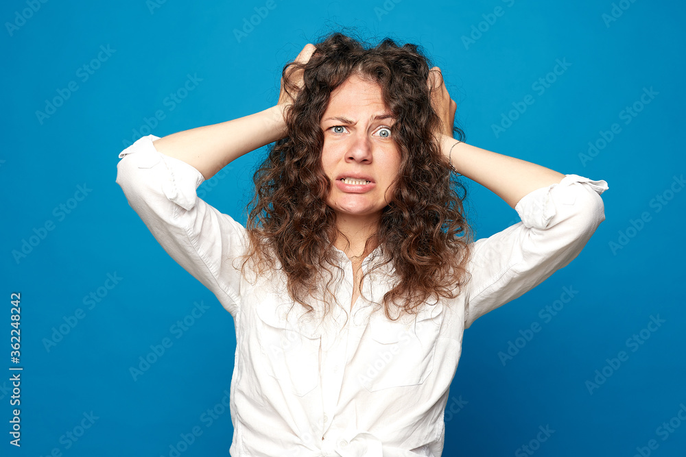 Depressed European female scratches head, looks with frustrated face ...