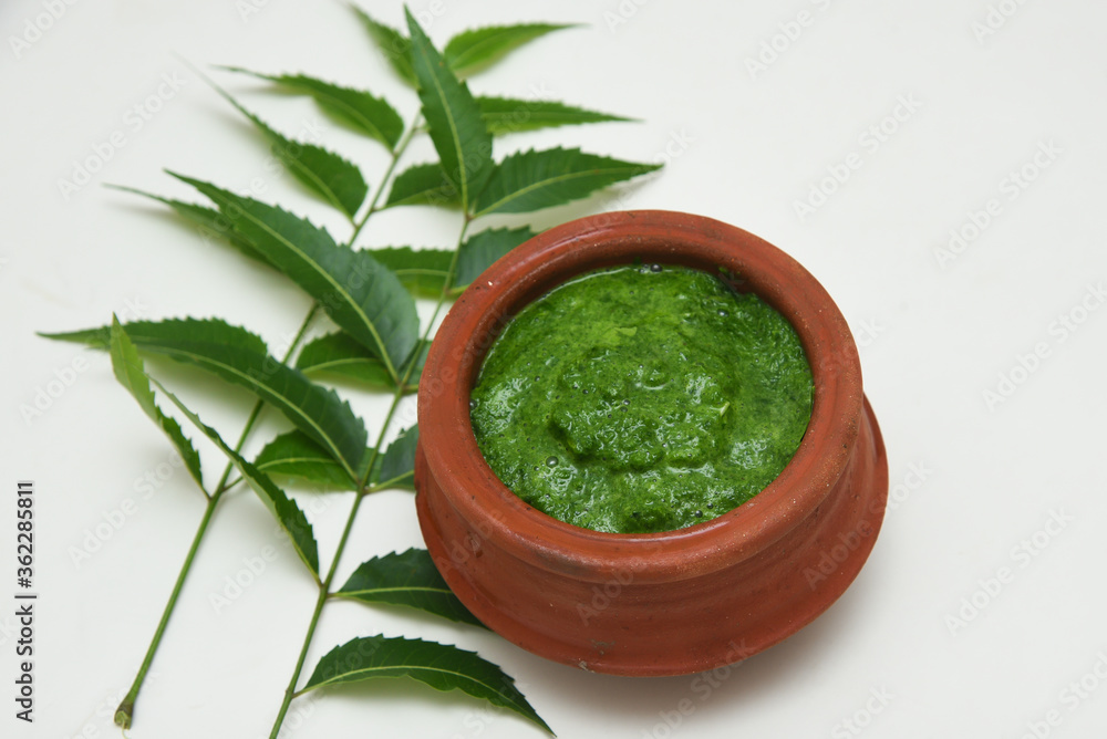 Neem leaves used as ayurvedic medicine with ground paste over white ...