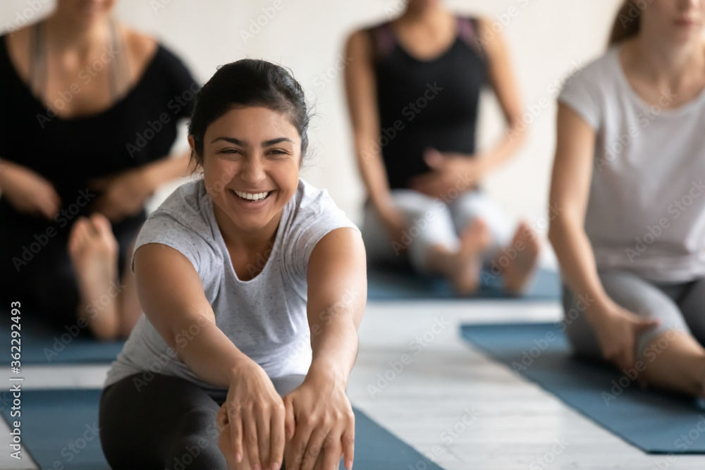 Happy young indian woman excited by flexibility progress in seated ...