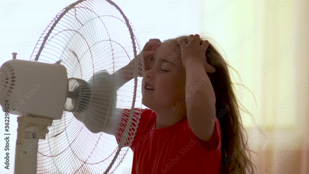 Girl Standing in Front of Fan. Child Enjoying Cool Wind From Electric ...