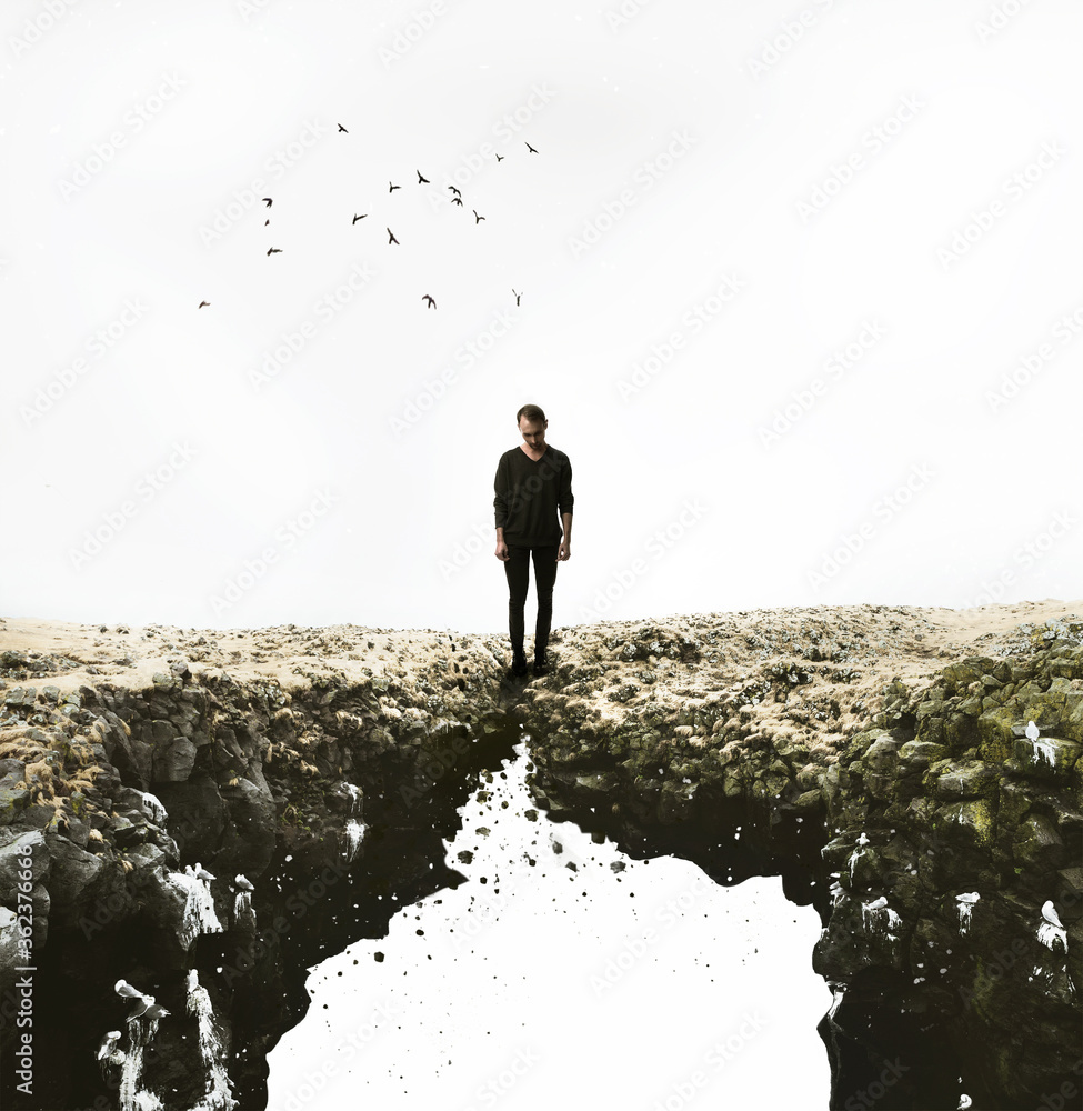 Man standing close to the edge on cliff. Ground is destroying under his ...