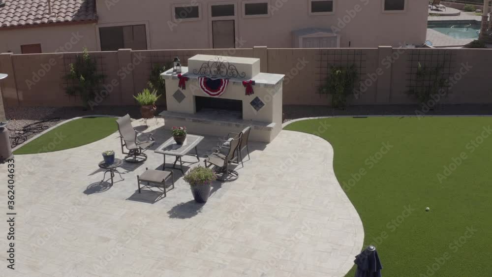 A 4k high definition aerial view of an outdoor fireplace and tile patio ...