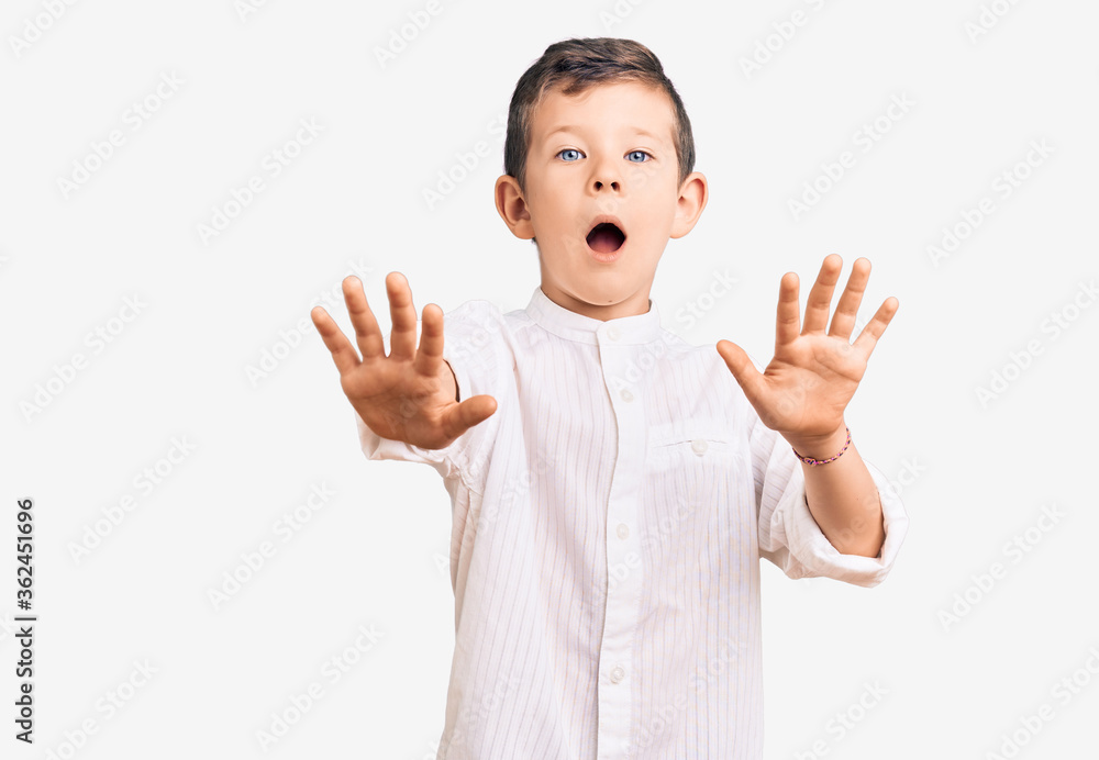 Cute blond kid wearing elegant shirt afraid and terrified with fear ...