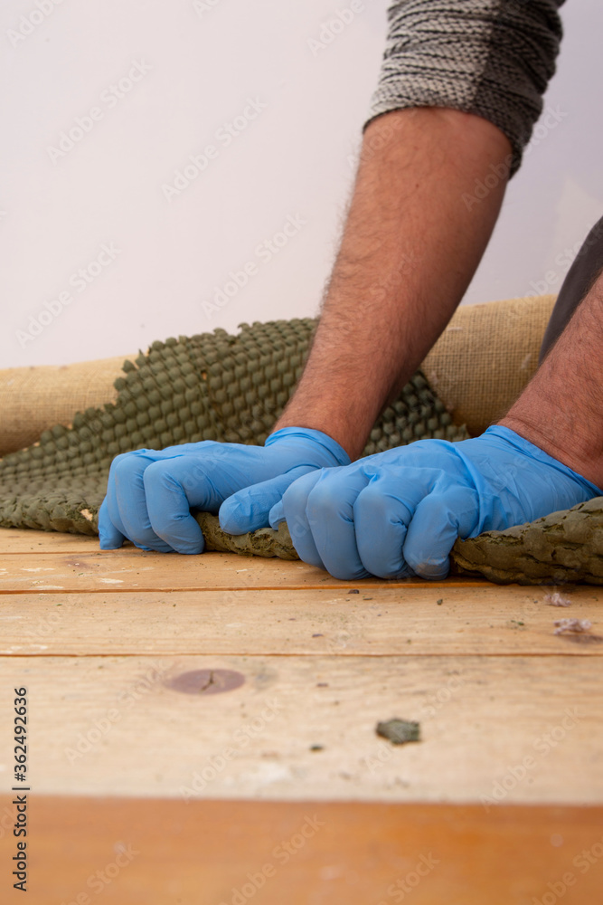 Man pulling up and removing carpet underlay from a wooden floor. Home ...