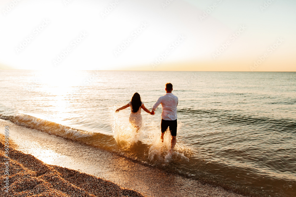 Loving couple in white clothes during a honeymoon at sea walk on the ...