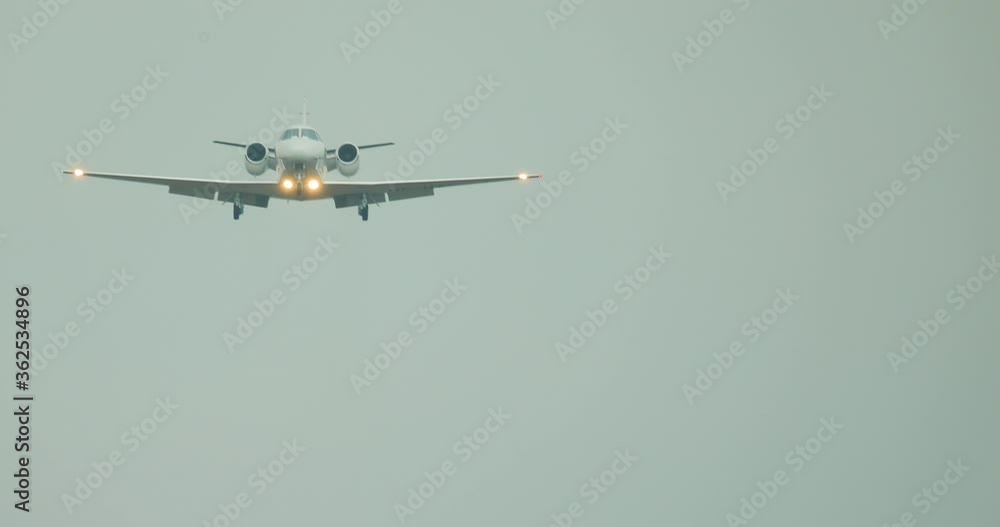 A light plane lands at the airport. The plane with the light on flies ...