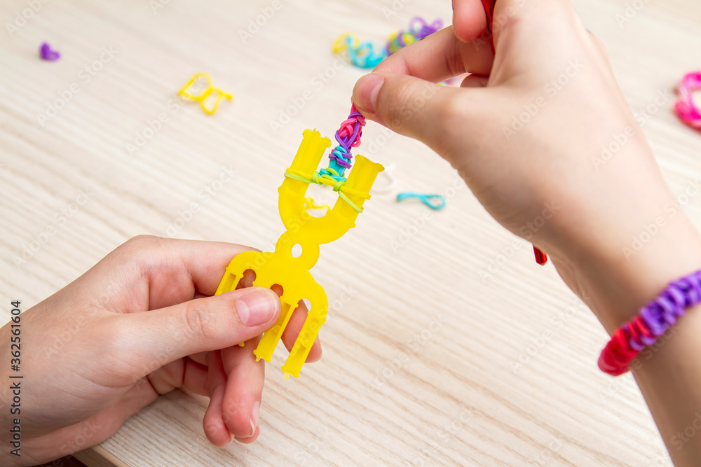 Rubber Band Weaving. Knitting rubber bands with loom knit. Hands of ...