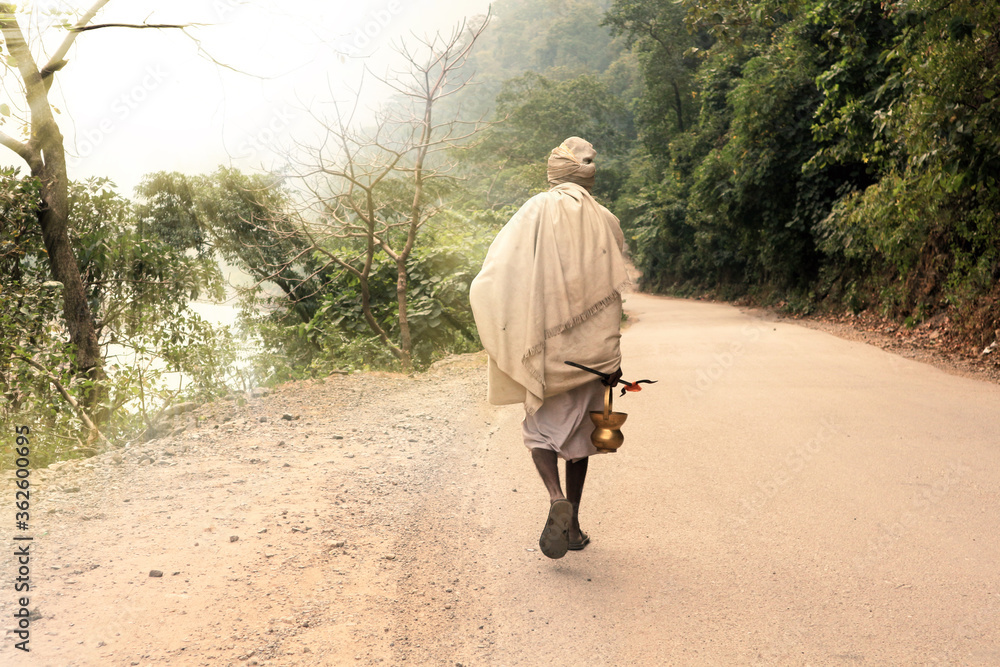 Indian renounced sadhu leaves on the way to the forest. A wandering ...