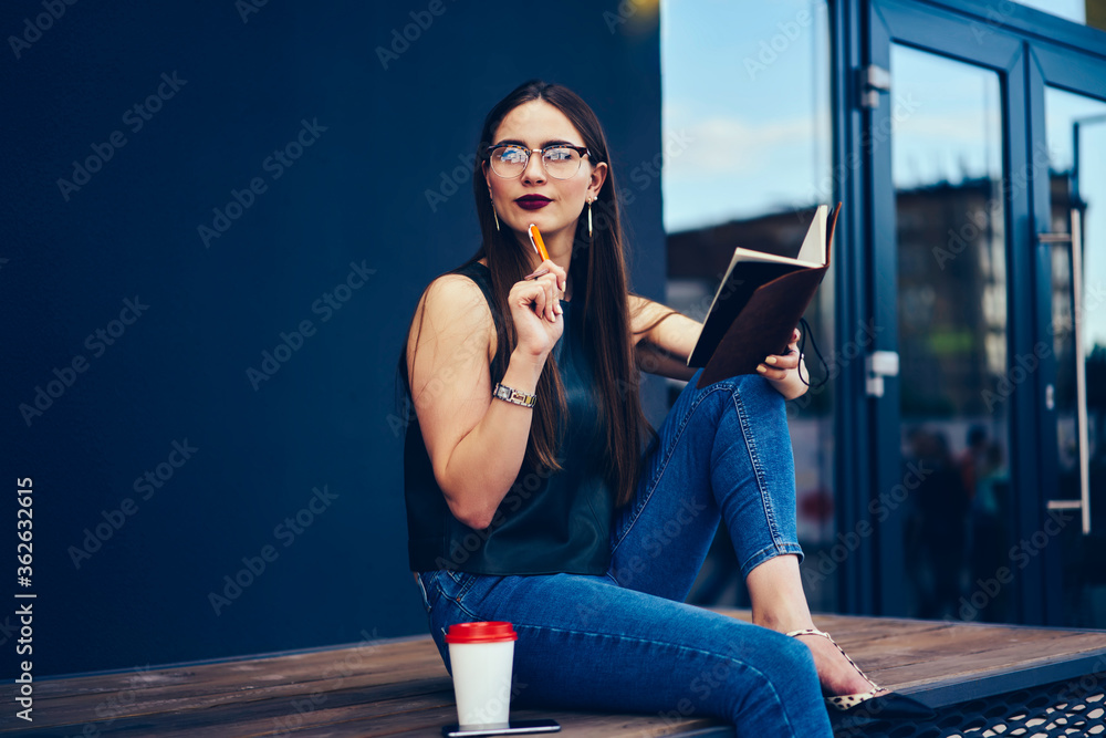 Contemplative gorgeous female student in cool eyeglasses thinking about ...