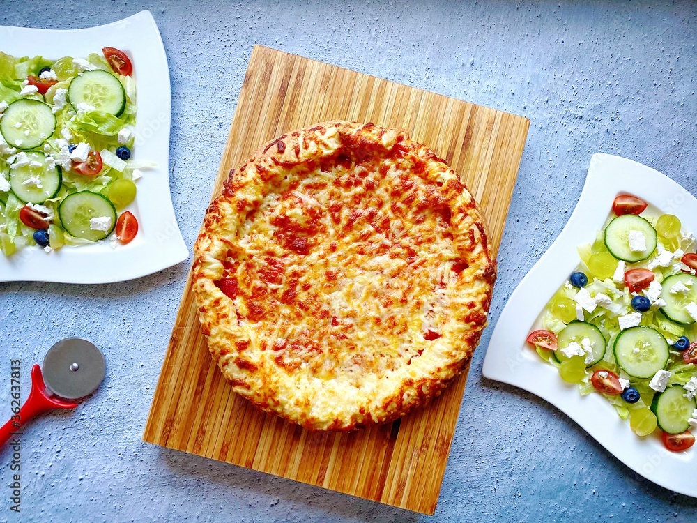 Top down view of freshly baked deep pan cheese and tomato pizza with a ...