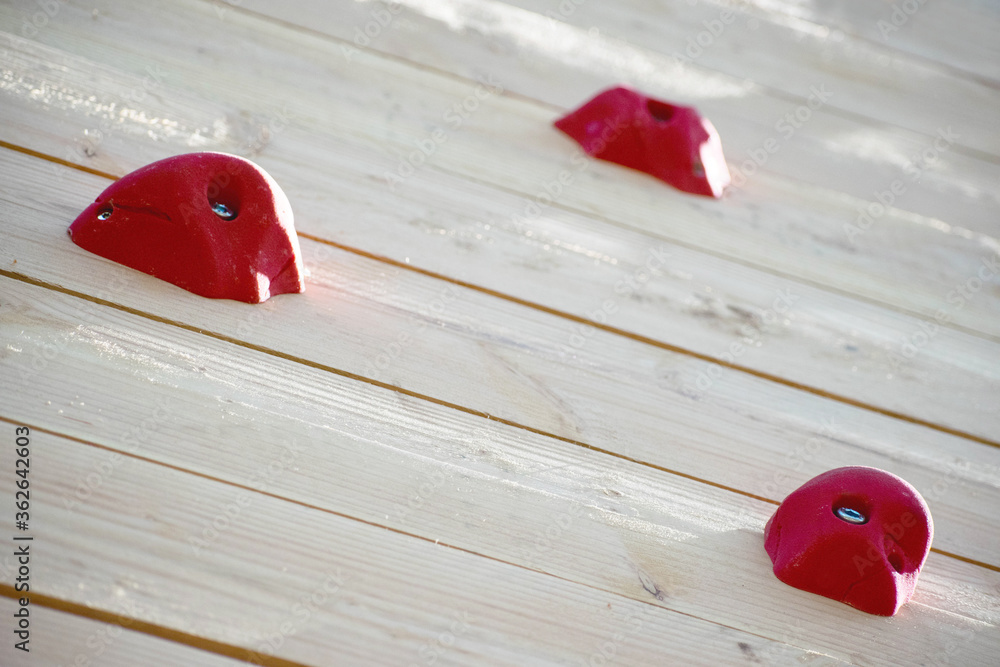 red hand holds wooden outdoor climbing wall. Exercise equipment. Home ...