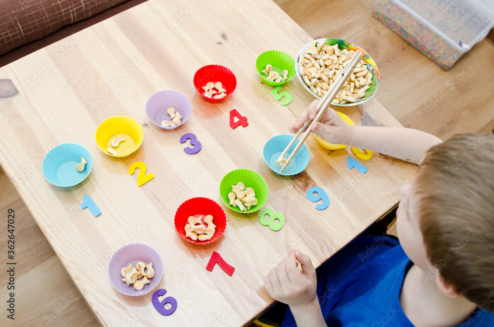 Little child doing simple math exercises. Early education, counting ...