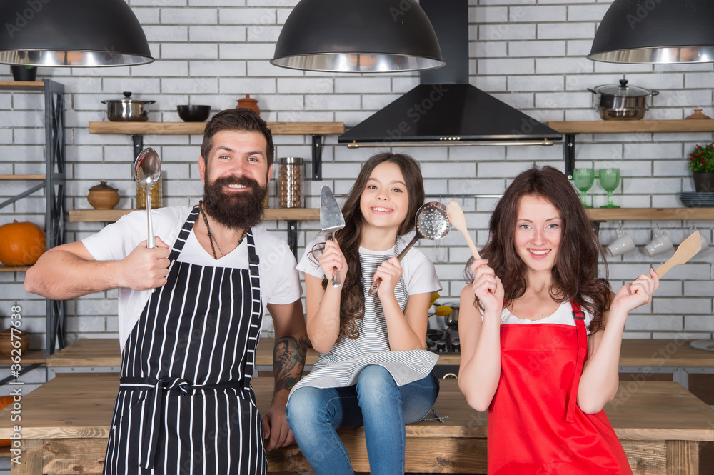 father and mother with daughter cook in kitchen. little girl cooking ...