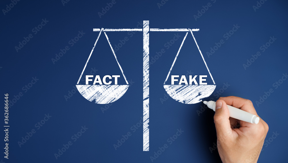 fact fake Concept. a man draws scales with the words fact and fake on ...