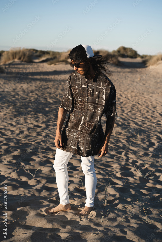 Fotka „Modelo de estilo surfero con pelo largo, gafas de sol y gorra ...