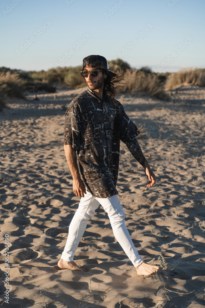 Modelo de estilo surfero con pelo largo, gafas de sol y gorra, en unas ...