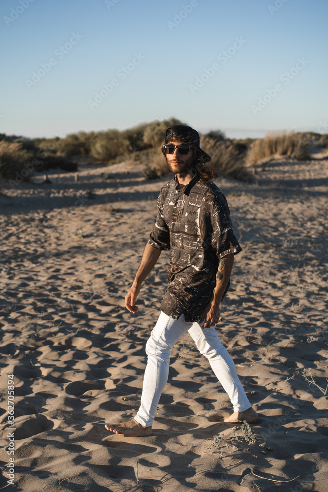 Modelo de estilo surfero con pelo largo, gafas de sol y gorra, en unas ...