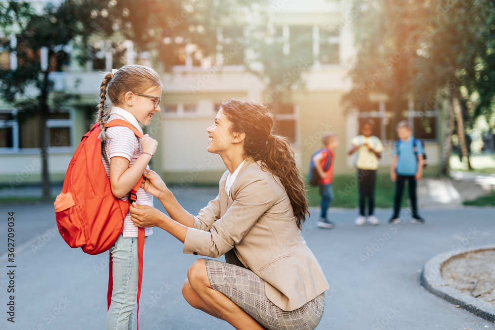 First day at school. Mother leads a little child school girl in first ...
