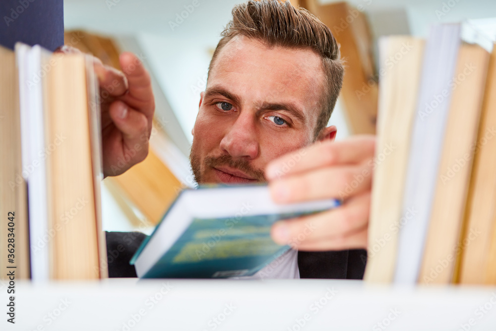 Librarian looks for book on the shelf of the library Stock Photo ...