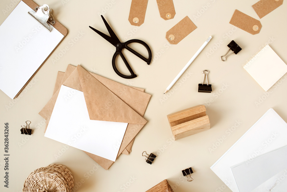 Blank paper sheet with envelope on beige table. Artist home office desk ...