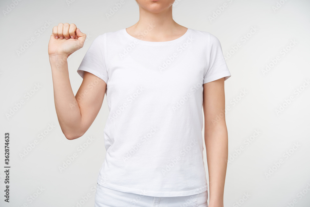 Indoor photo of young lady in casual clothes keeping hand raised while ...