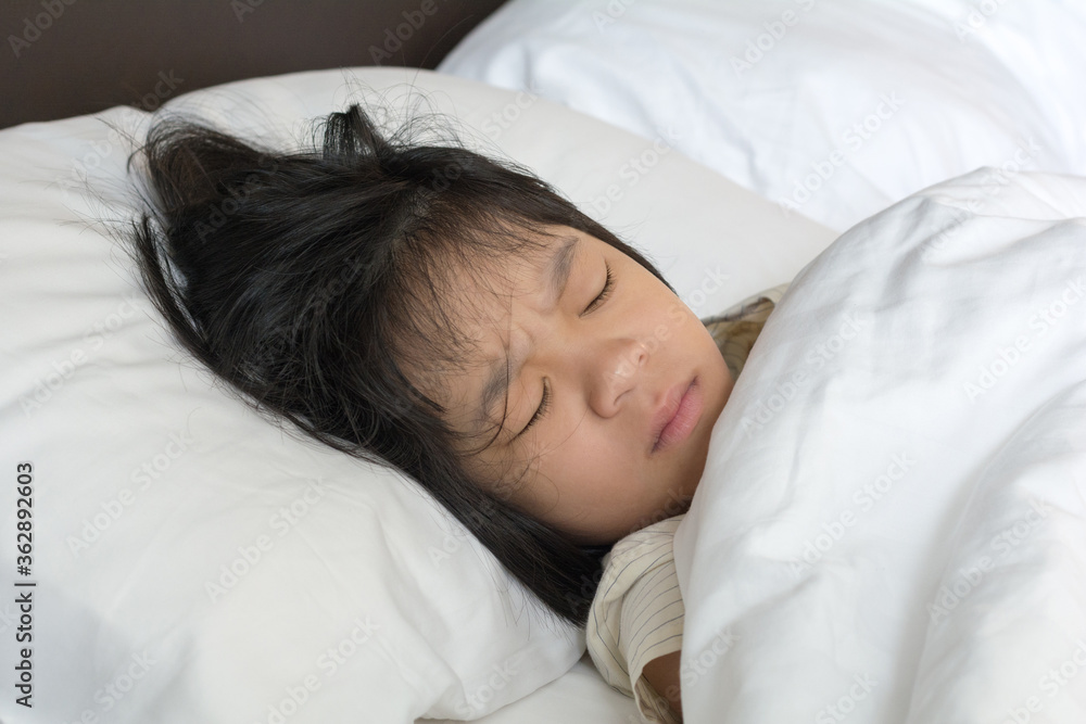 Portrait of Asia adorable child girl sleeping with frown as having ...