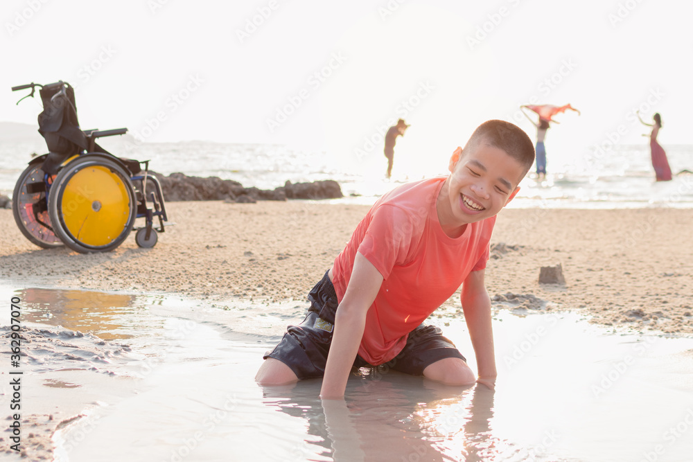 Asian special child playing sand and crawls happily on the beach near ...