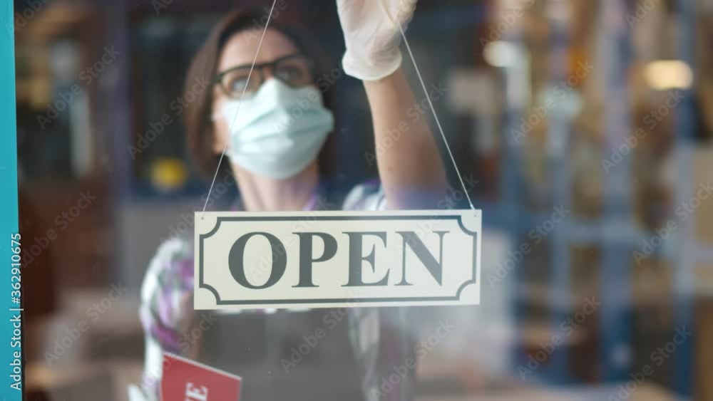 Waitress in medical mask replacing open sign with quarantine sign on ...