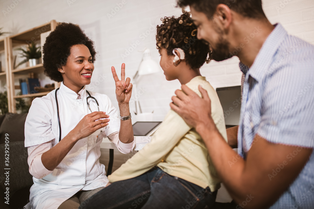 Smiling deaf african american girl with ear implant at doctor's office ...