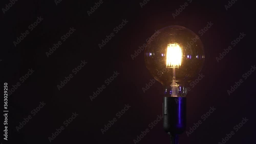 Incandescent light bulb isolated on black background. Glass and metal ...