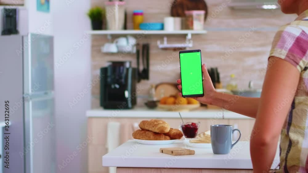 Video Stock Holding phone with green touch screen in kitchen and ...
