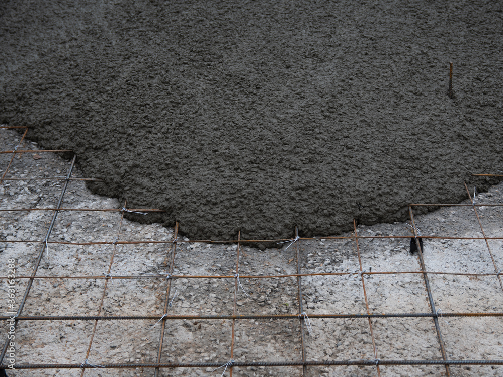 concrete is spread in the formwork along the reinforcement grid foto de ...