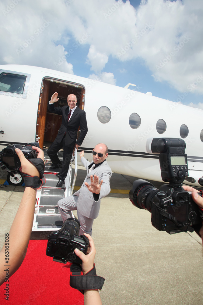 Businessman descending from private jet with his bodyguard, paparazzi ...