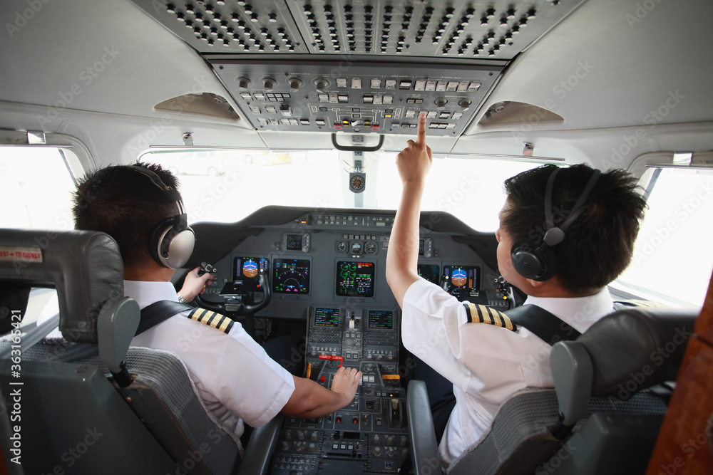 Pilot and co-pilot in private jet cockpit Stock Photo | Adobe Stock
