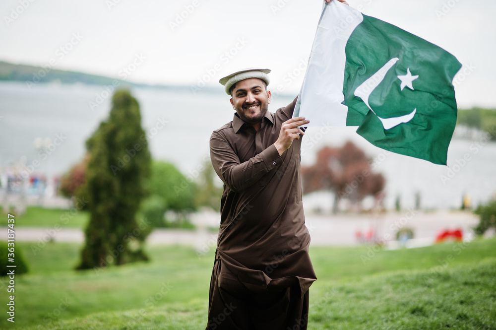 Pakistani pathan man wear traditional clothes hold Pakistan flag. Stock ...