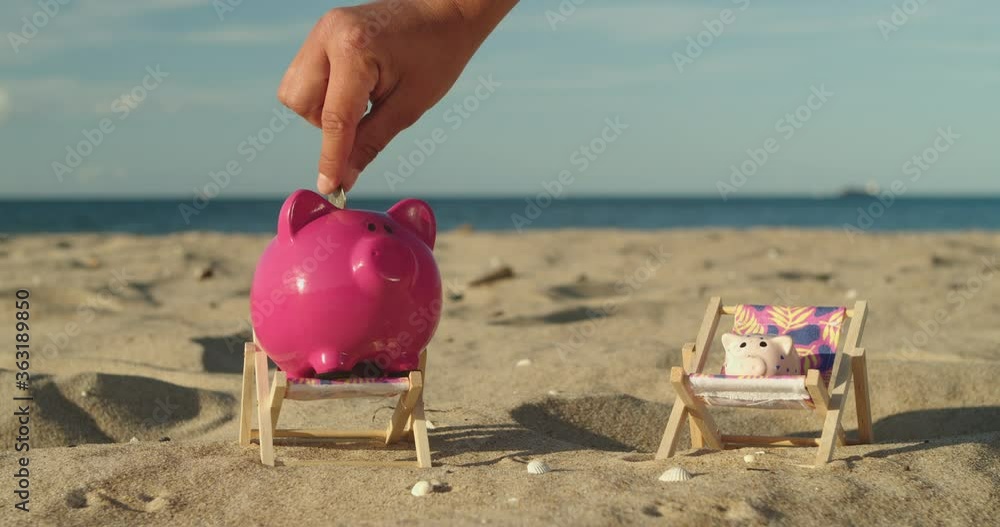 Two piggy banks pigs are sitting on sun loungers on the beach near the ...