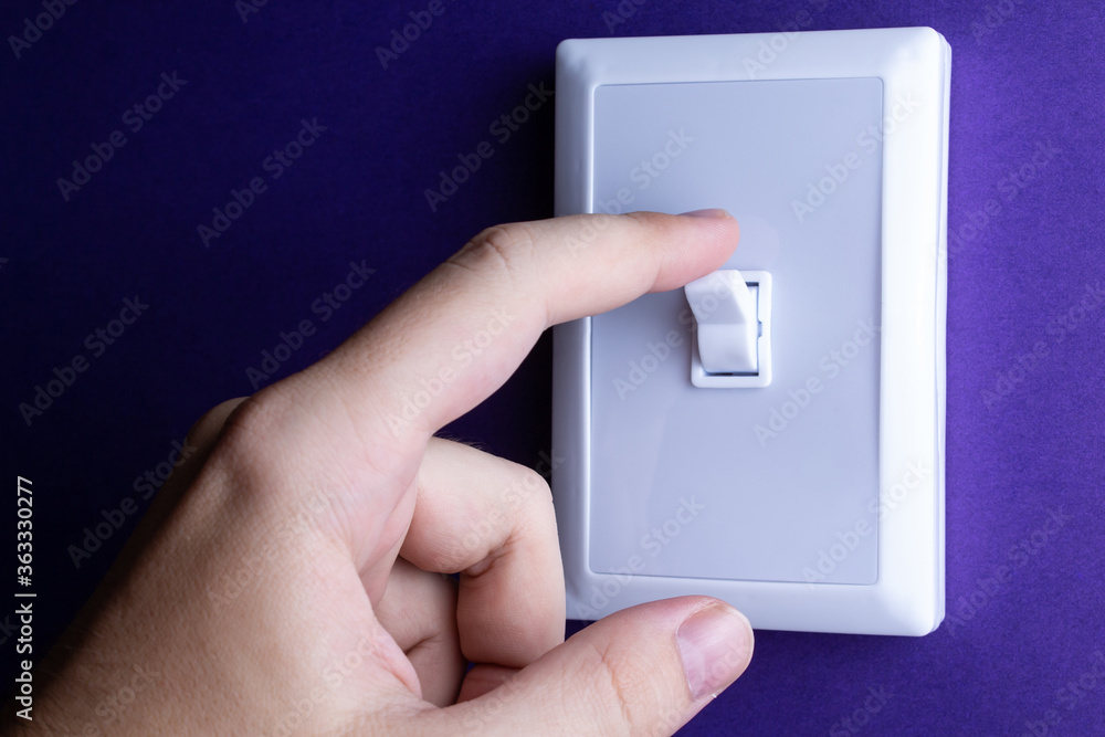 Man switches the switch to the lower position on a blue background ...